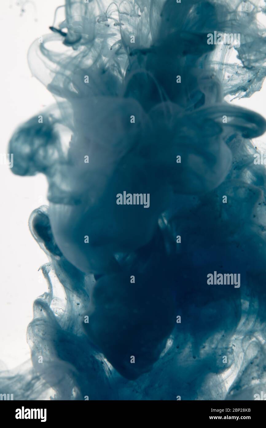 a beautiful image of a colorful light blue liquid mixing in water ...