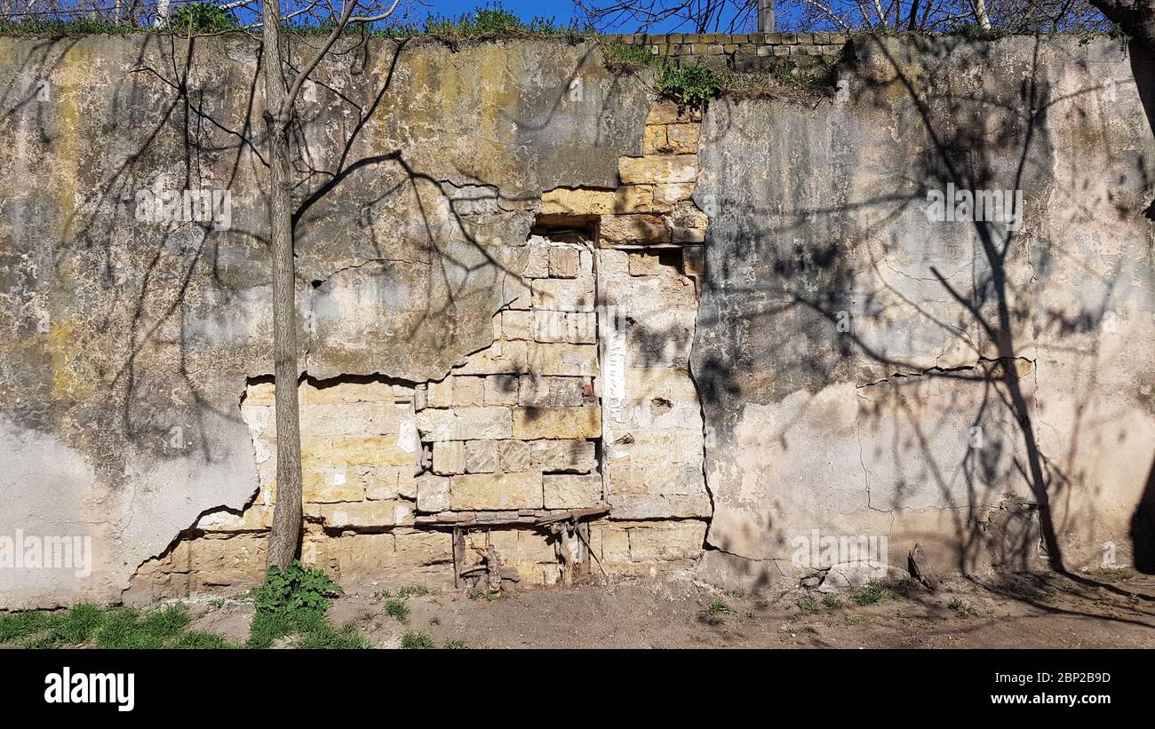 Dilapidated ancient wall with ruined plaster surface and damaged ...
