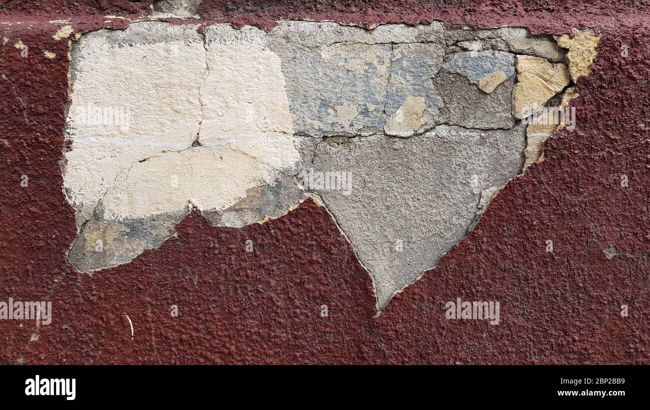 Weathered wall surface closeup with damaged peeling layer and cracked ...