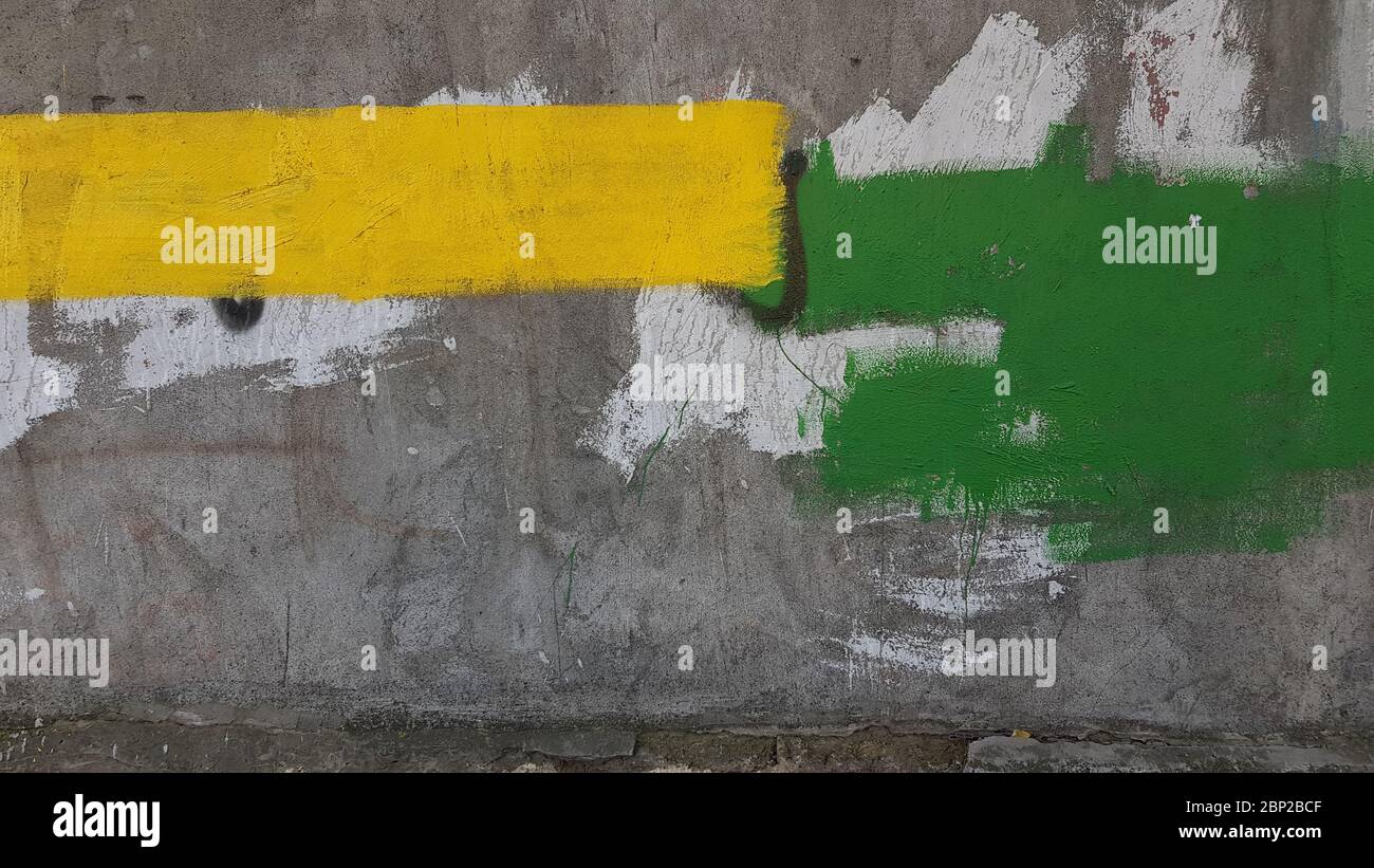 Old rough cement wall with rectangle stains of yellow and green stains ...