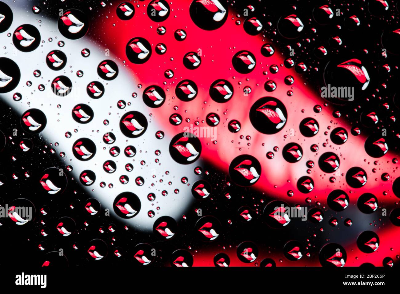 Lips close-up through drops of water on glass Stock Photo - Alamy