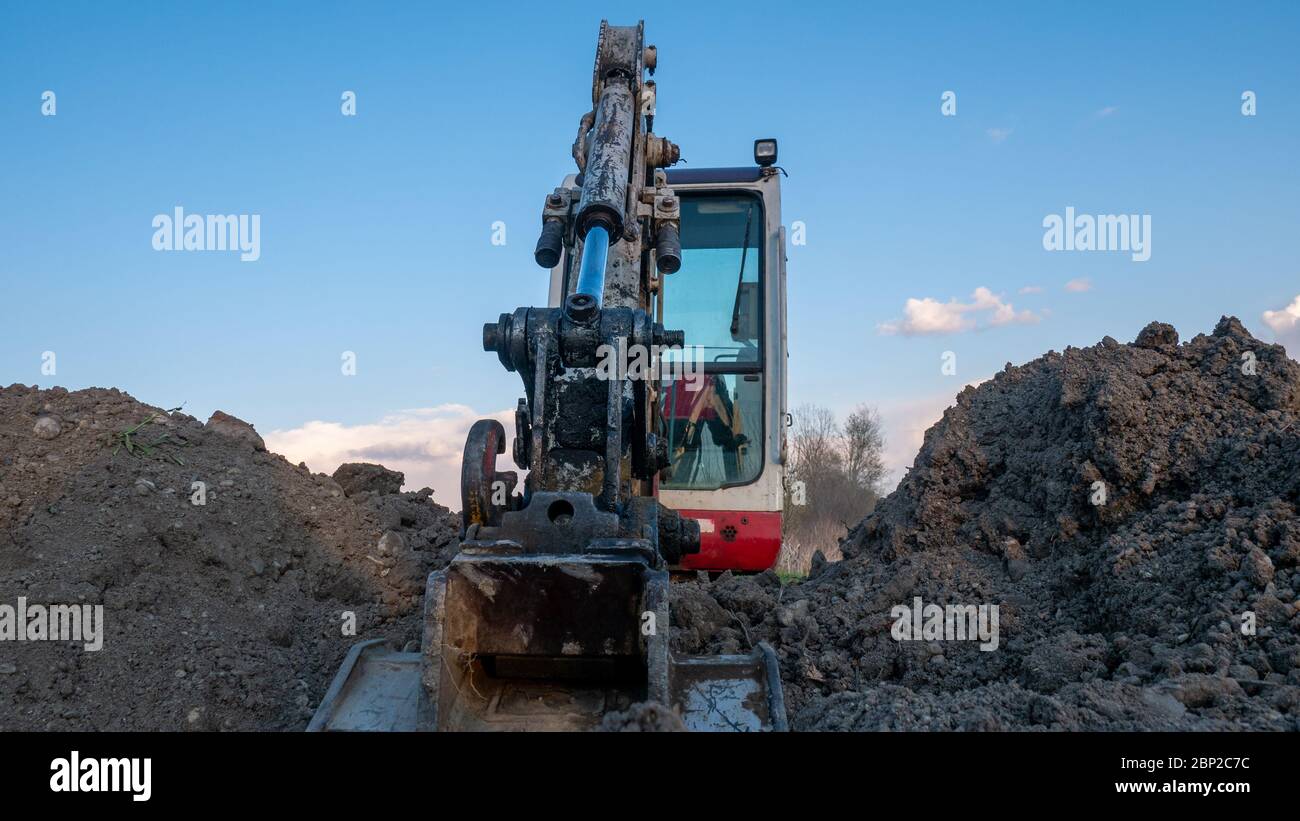 Crawler excavator front view digging on demolition site Stock Photo - Alamy