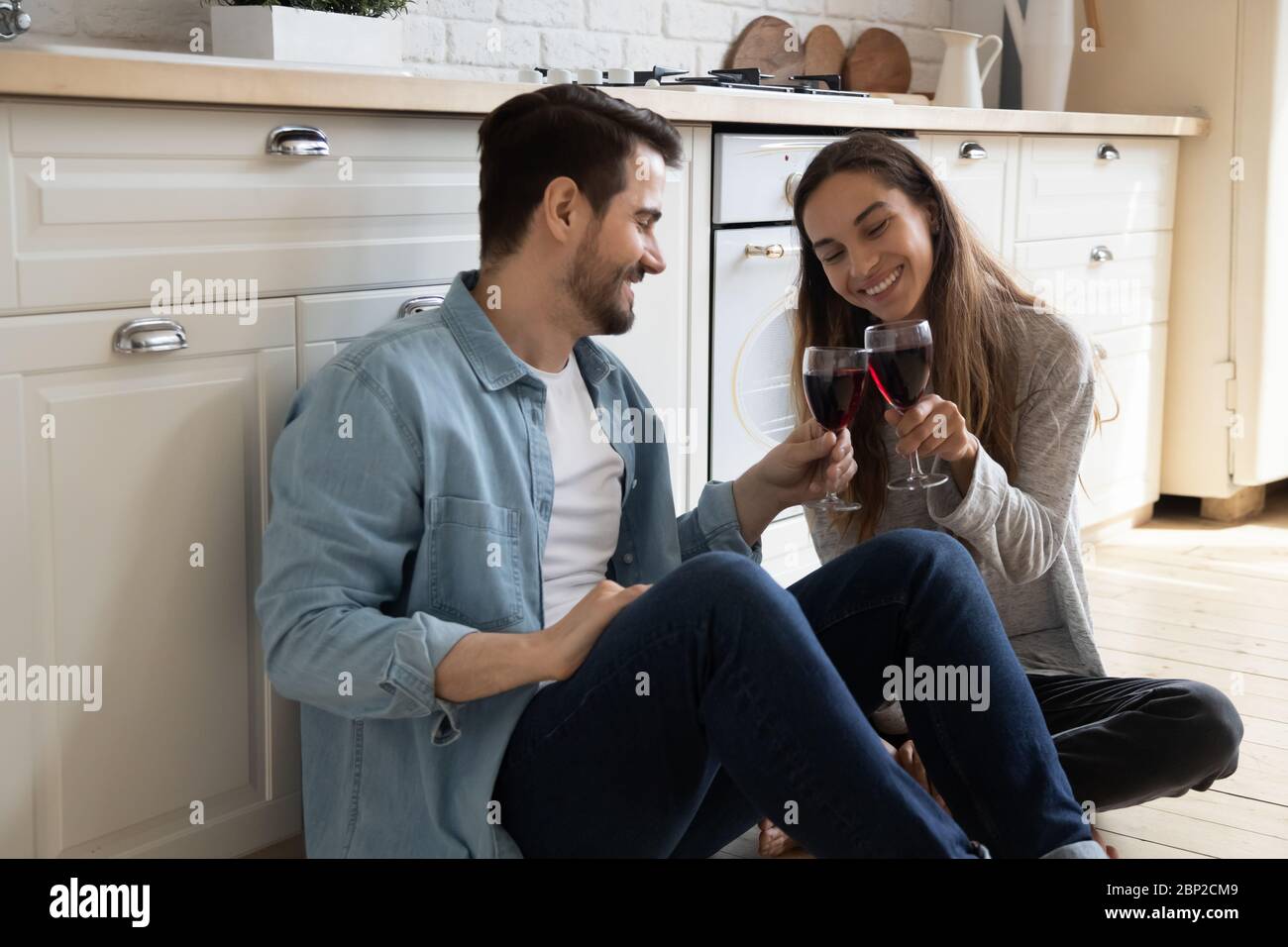Overjoyed couple sit on floor celebrate anniversary together Stock ...
