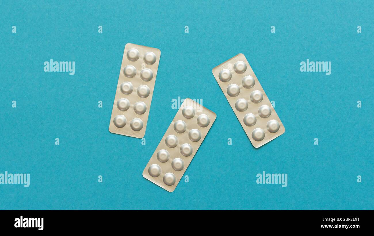 Blister packs with pills on a blue background, lowering blood ...