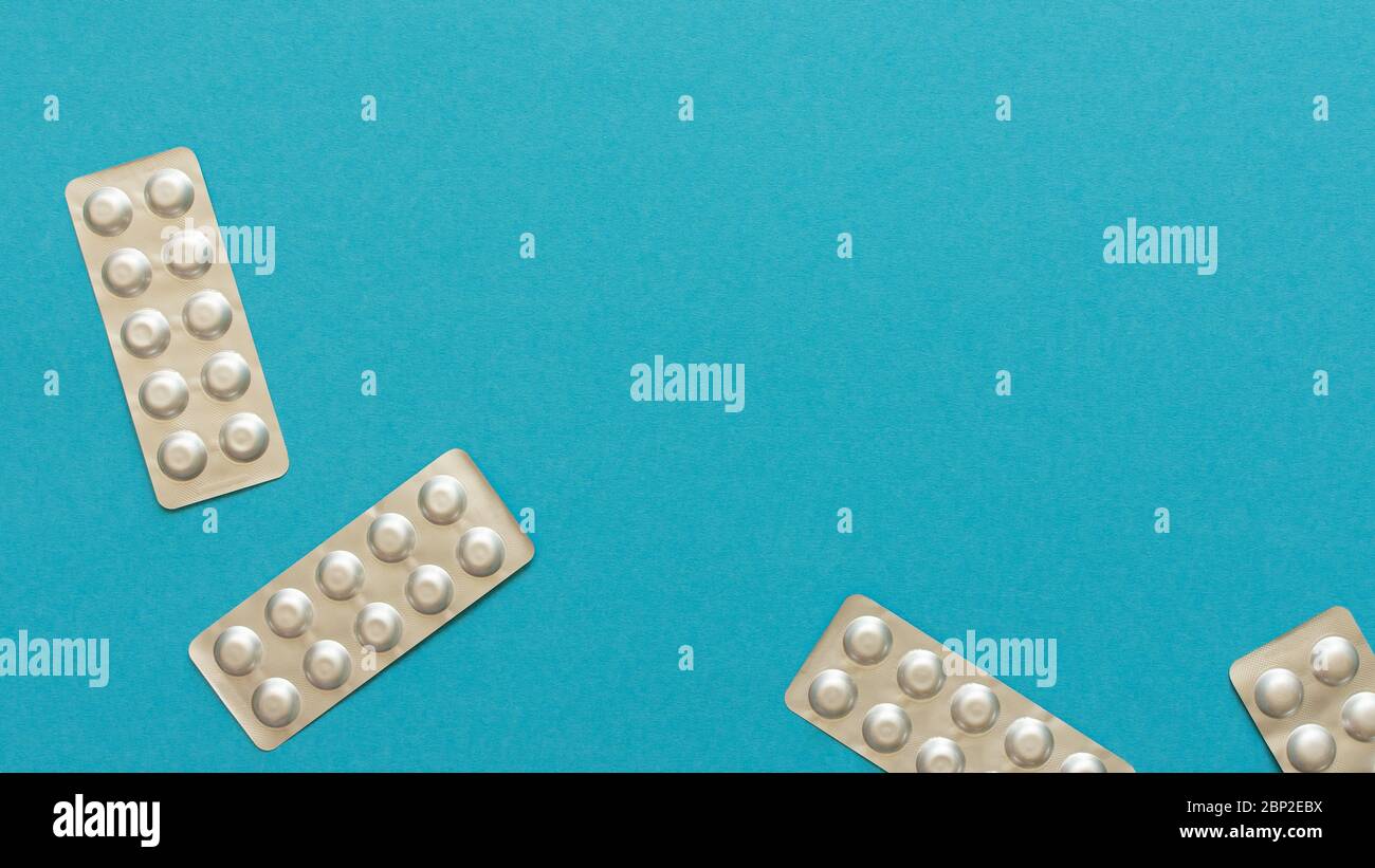 Blister packs with pills on a blue background, lowering blood ...