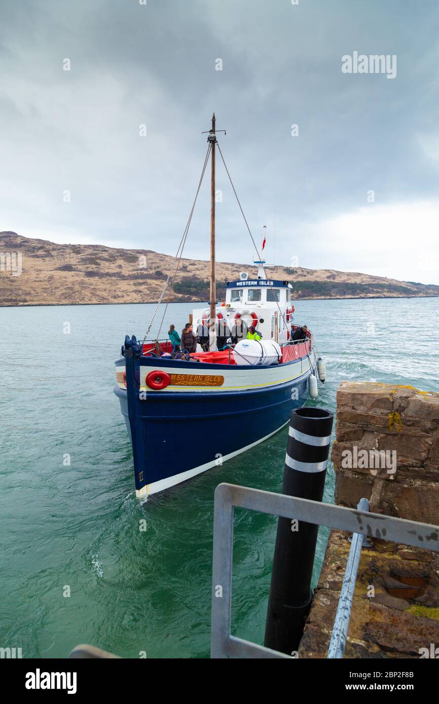 A small wooden ferry arriving at the small harbour at Kinloch on the ...