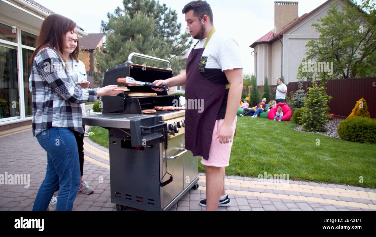 Man serving hot dogs to young women Stock Photo - Alamy