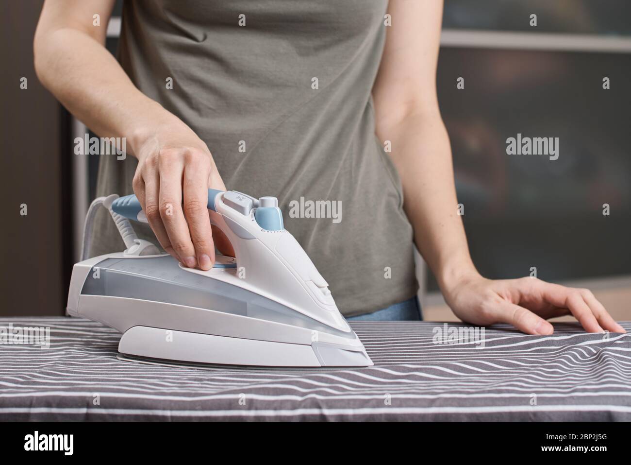 Woman ironing clothes on ironing board with modern iron Stock Photo - Alamy
