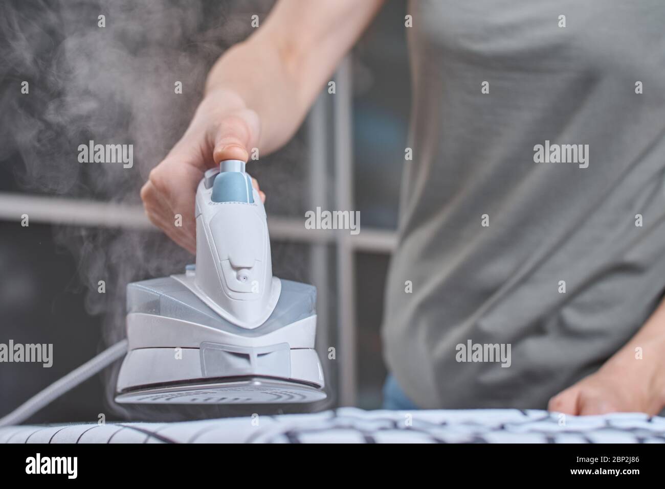 Woman ironing using steam iron hi-res stock photography and images - Alamy