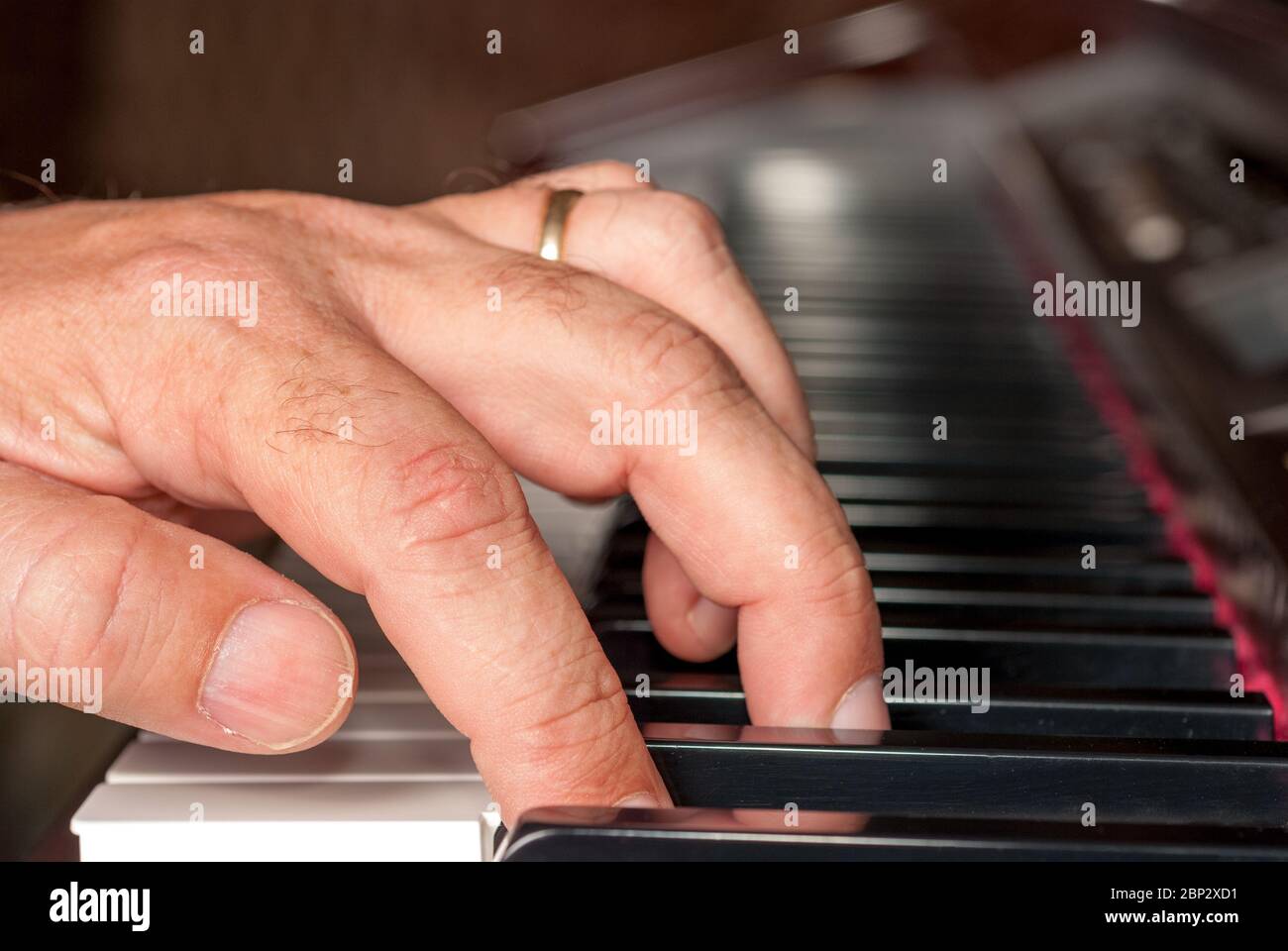 Hand presses the keys of a piano in rhythm Stock Photo - Alamy