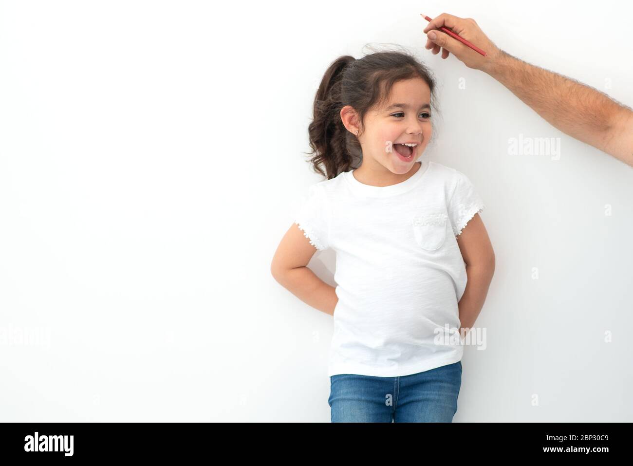 Father measuring height of a cute child. Dad measures the growth of her ...