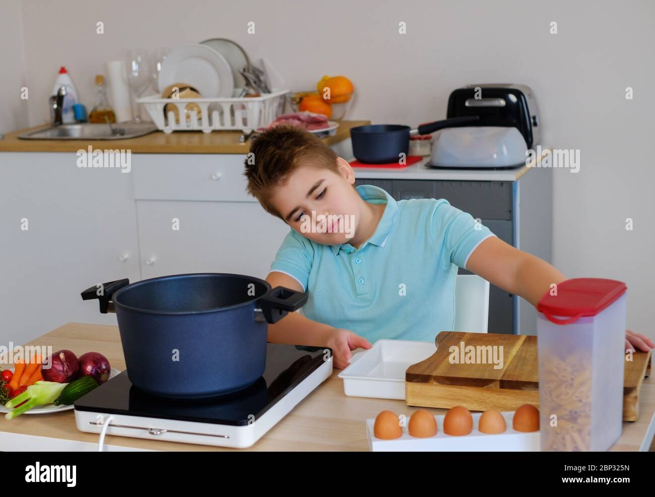 Little boy cooking at home Stock Photo - Alamy
