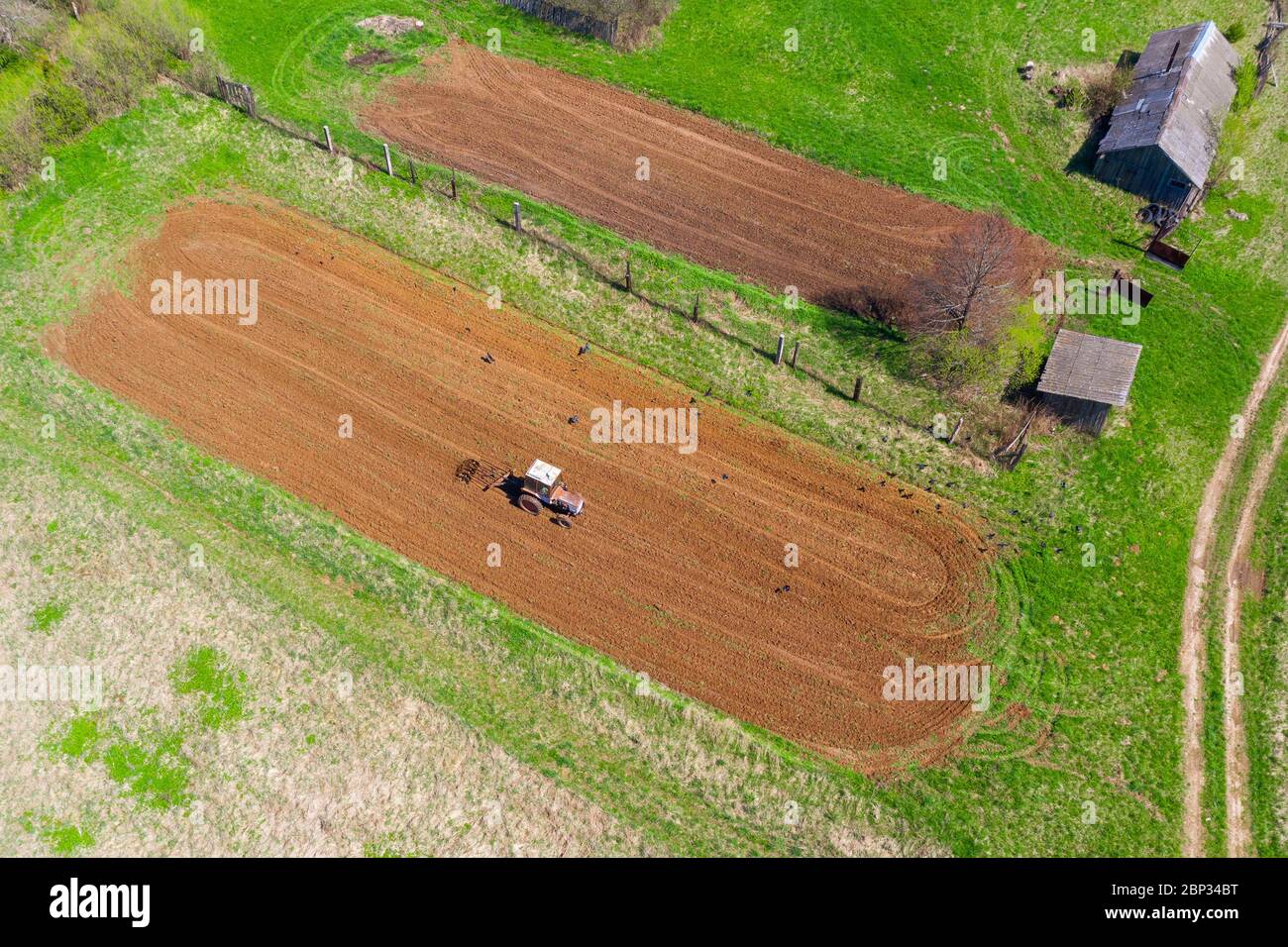 Tractor plows a small field in the village before planting vegetables ...