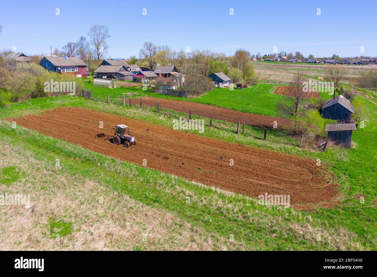 Tractor plows a small field in the village before planting vegetables ...