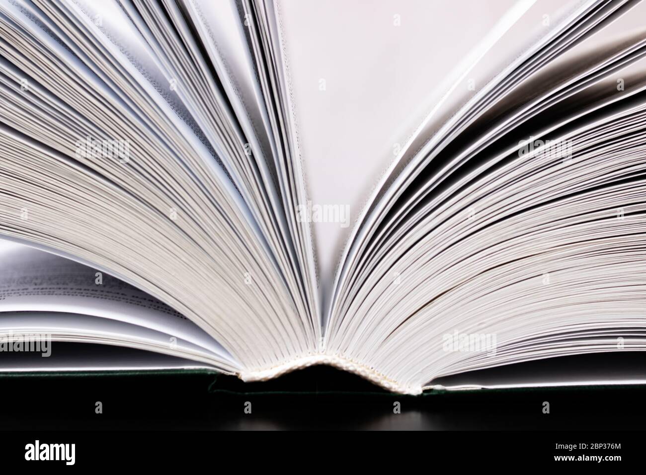 Illuminated open book pages in the dark close up Stock Photo - Alamy