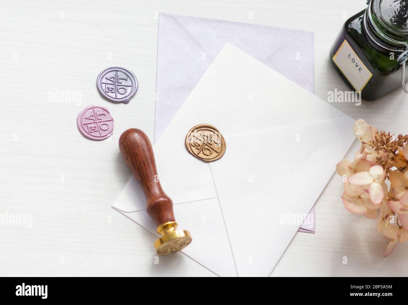 Stamp and envelope on a white table, top view Stock Photo - Alamy