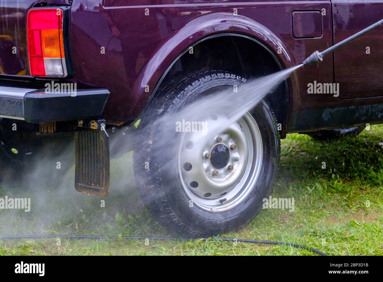 Car wash in the afternoon outdoors with a high-pressure apparatus. A ...
