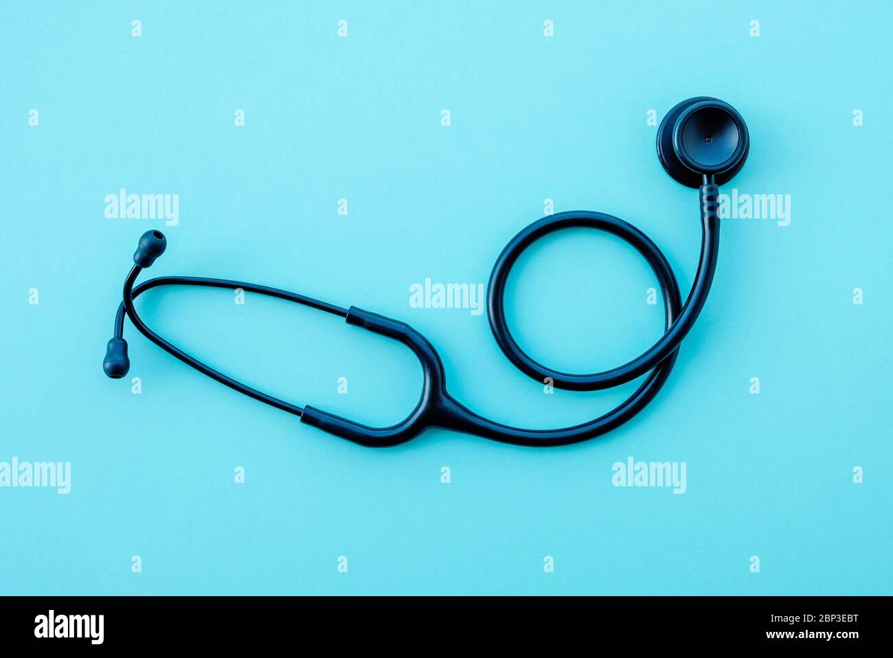 Black modern stethoscope on light blue background Stock Photo - Alamy