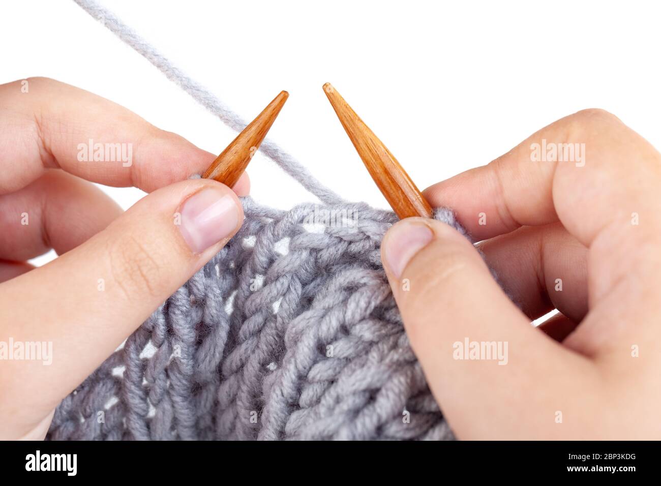 Women's hands knit from grey wool on white background. Hand knitting ...