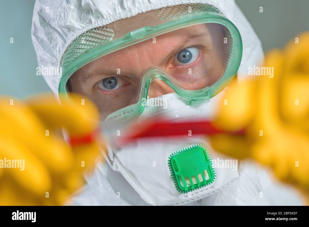 Epidemiologist examining medical sample test tube in virus quarantine ...