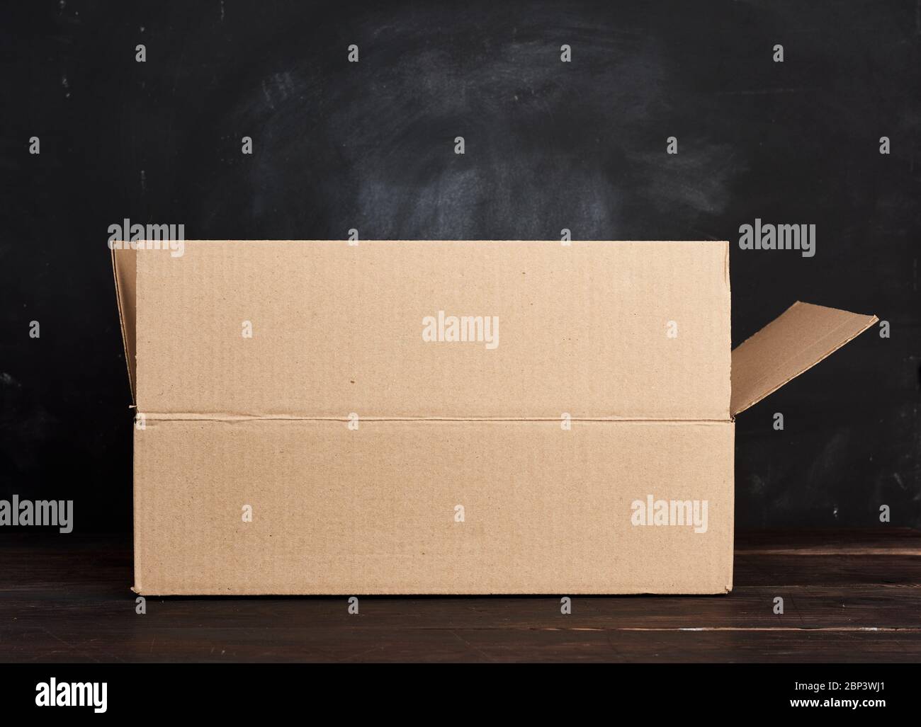 open cardboard box stands on a brown table, concept of moving and ...
