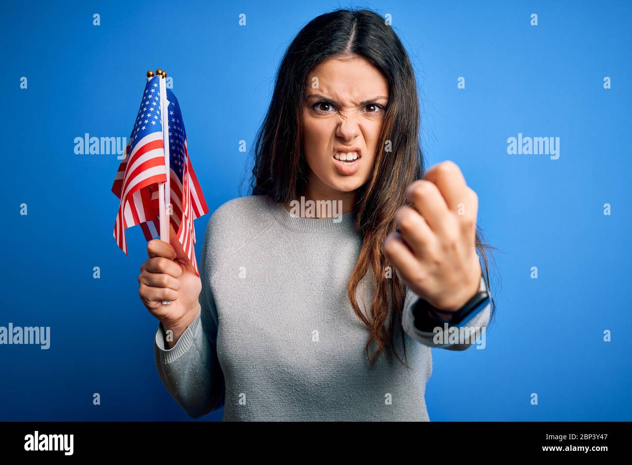 Young beautiful brunette patriotic woman holding american flag ...