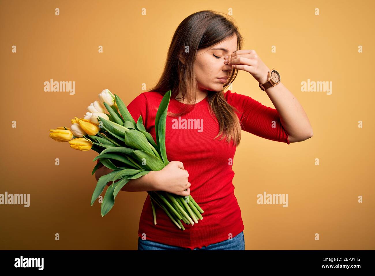 Young blonde woman holding romantic bouquet of tulips flowers over ...