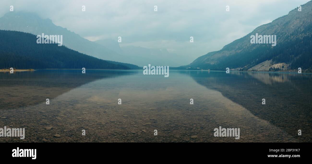 Lake at dusk with reflections and mountains in Banff National Park ...