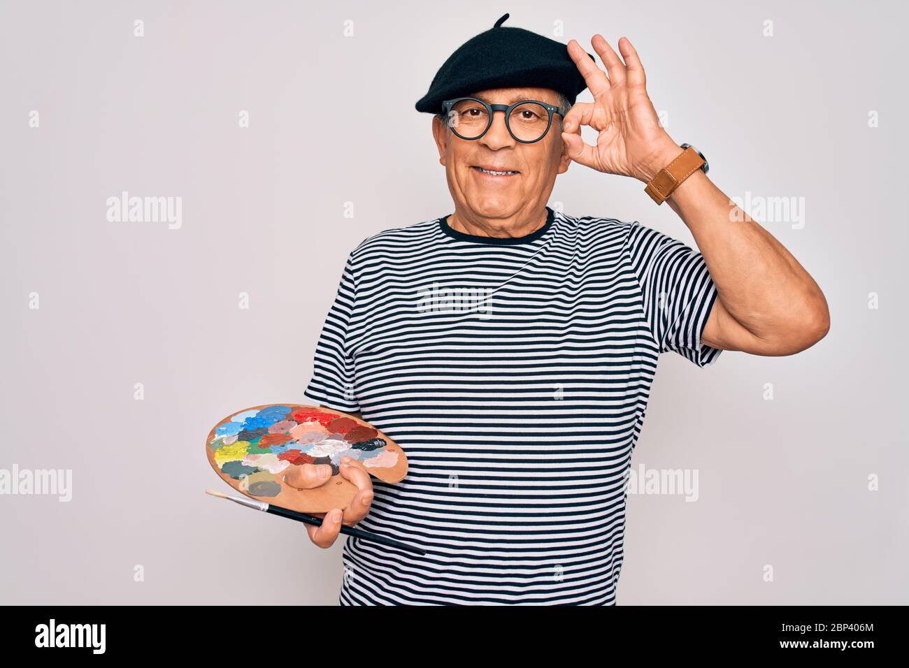 Senior hoary artist man wearing french beret drawing using paintbrush ...
