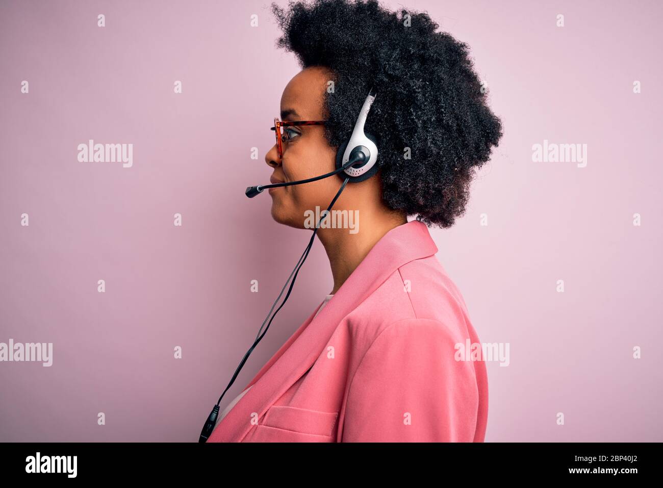 Young African American call center operator woman with curly hair using ...