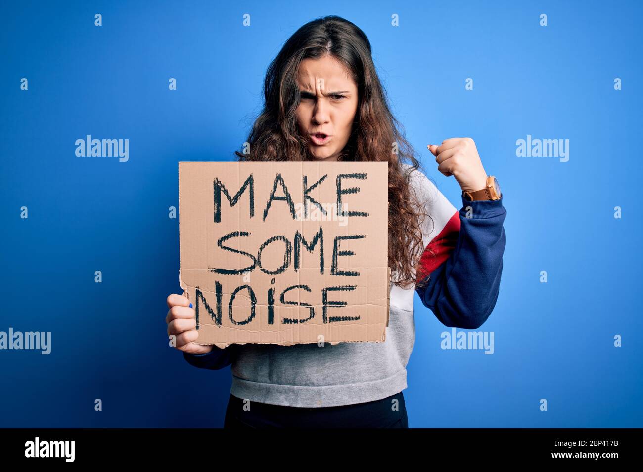 Beautiful activist woman holding banner with make some noise message ...