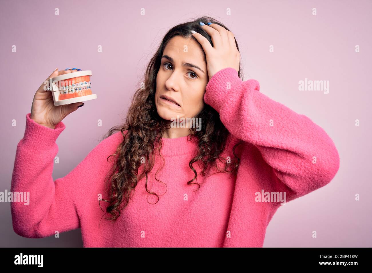 Beautiful woman with curly hair holding plastic teeth with dental ...