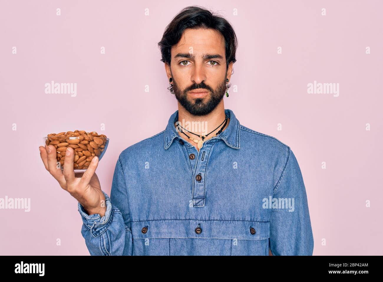 Young handsome hispanic man with bear holding natural ingredient ...