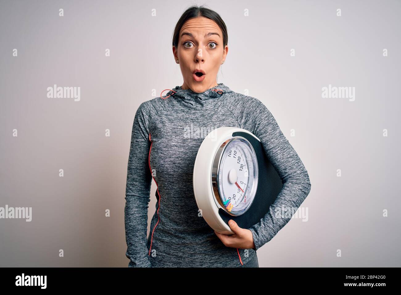 Young fitness woman wearing sport workout clothes holding scale for ...