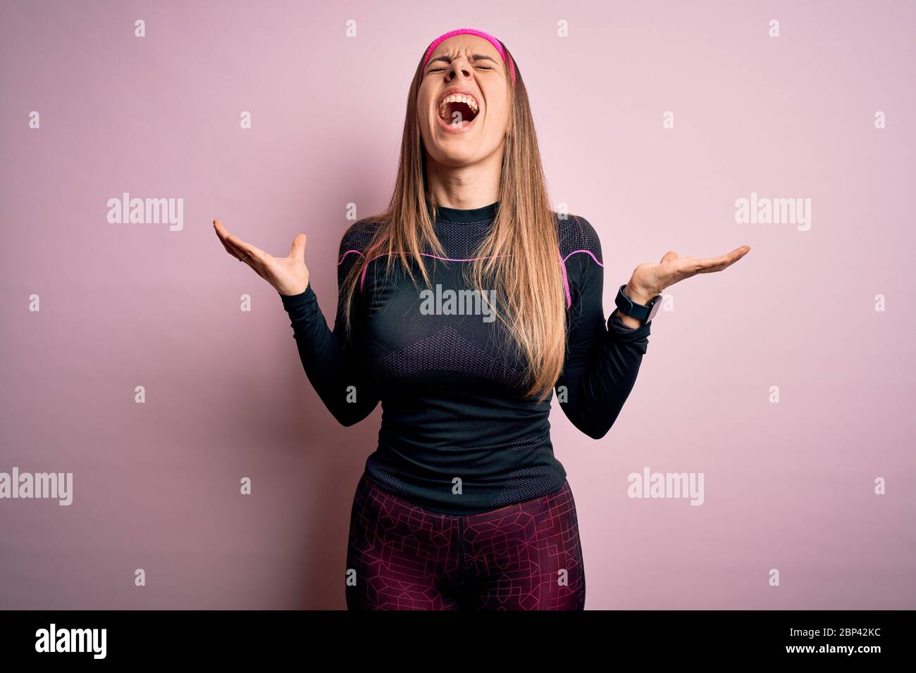 Young blonde fitness woman wearing sport workout clothes over isolated ...