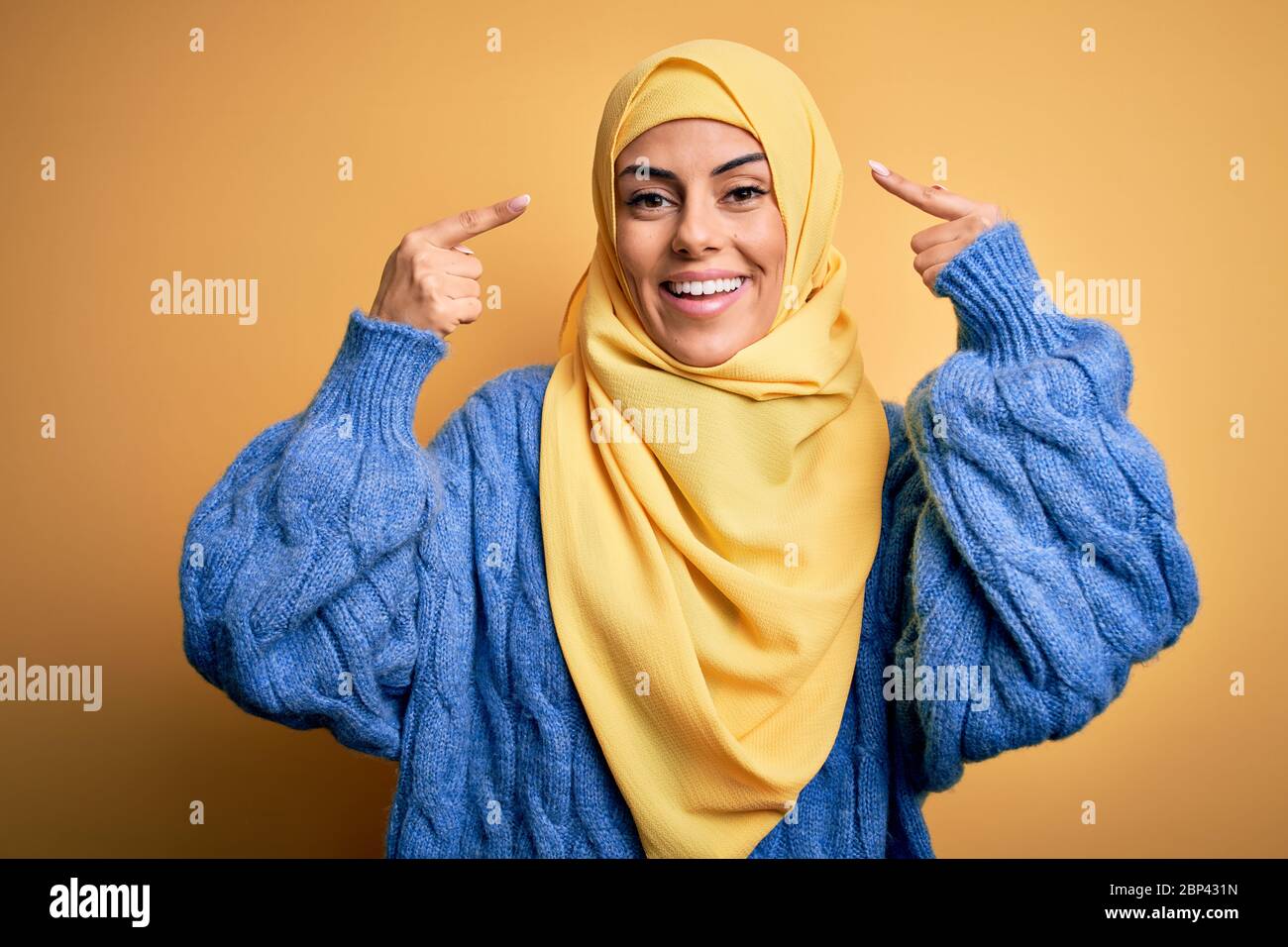 Young beautiful brunette muslim woman wearing arab hijab over isolated ...