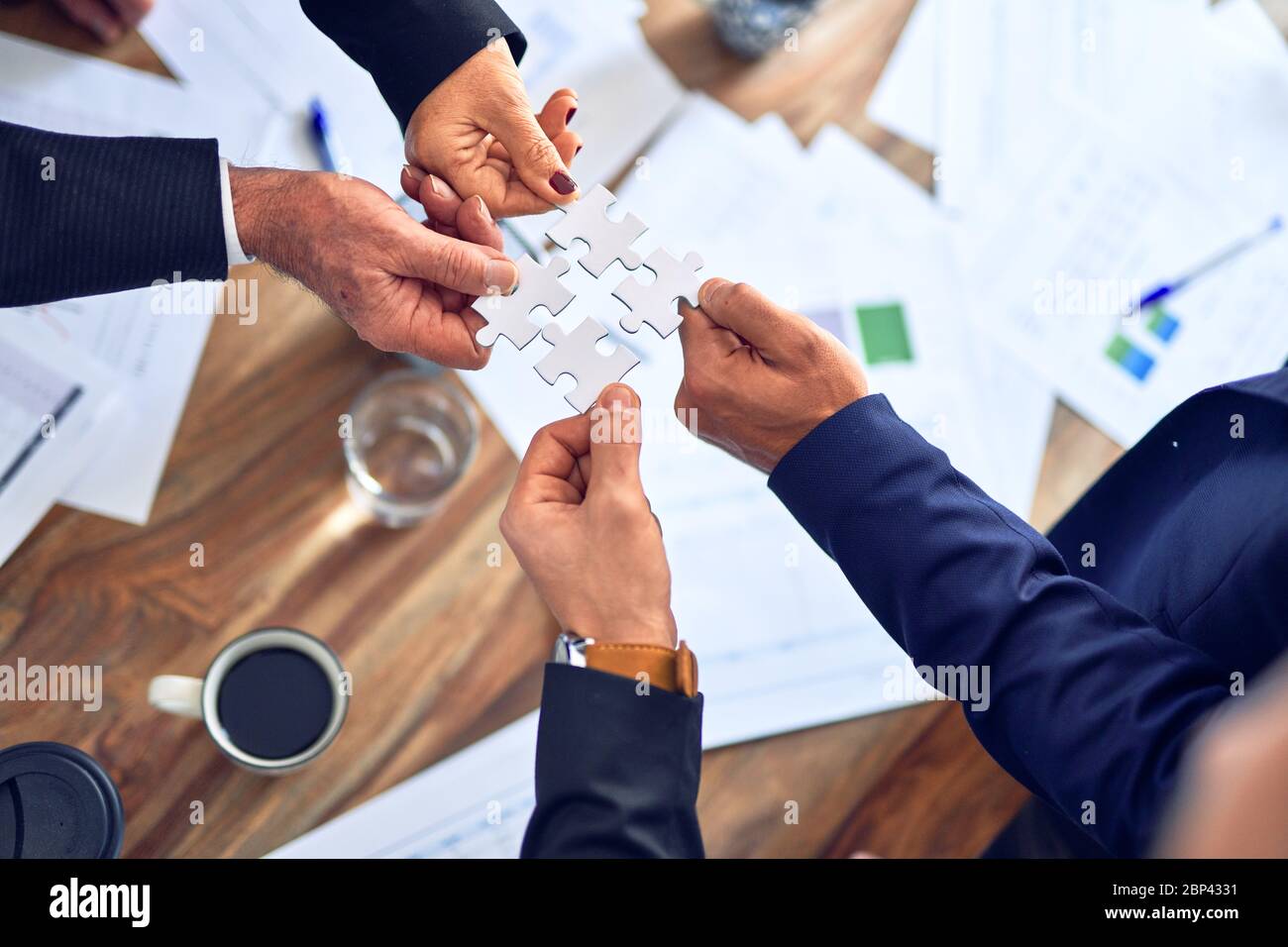 Group of business hands trying to connect puzzle pieces at office Stock ...