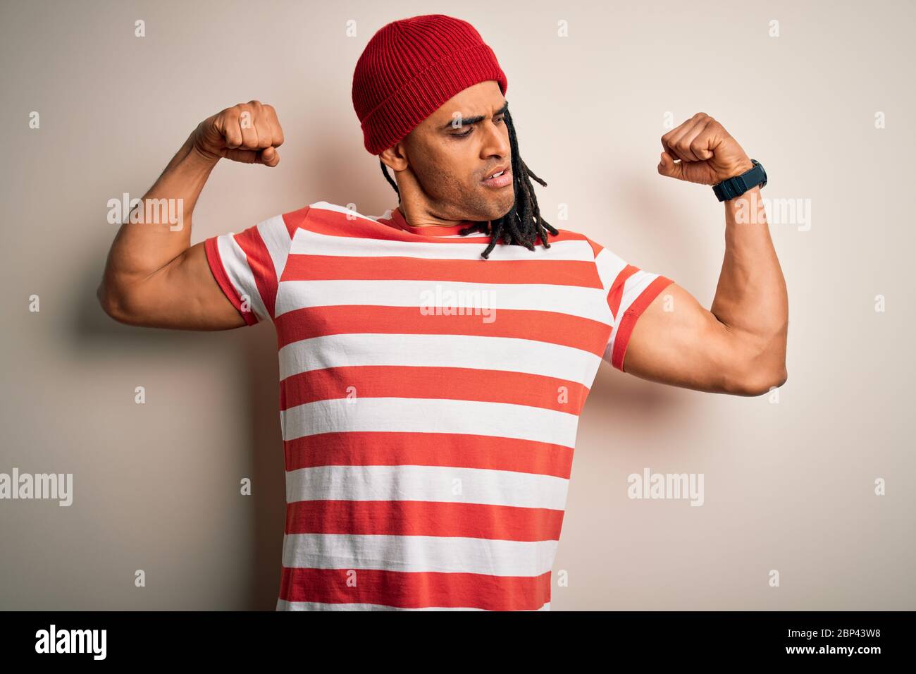 Young handsome african american man with dreadlocks wearing striped t ...