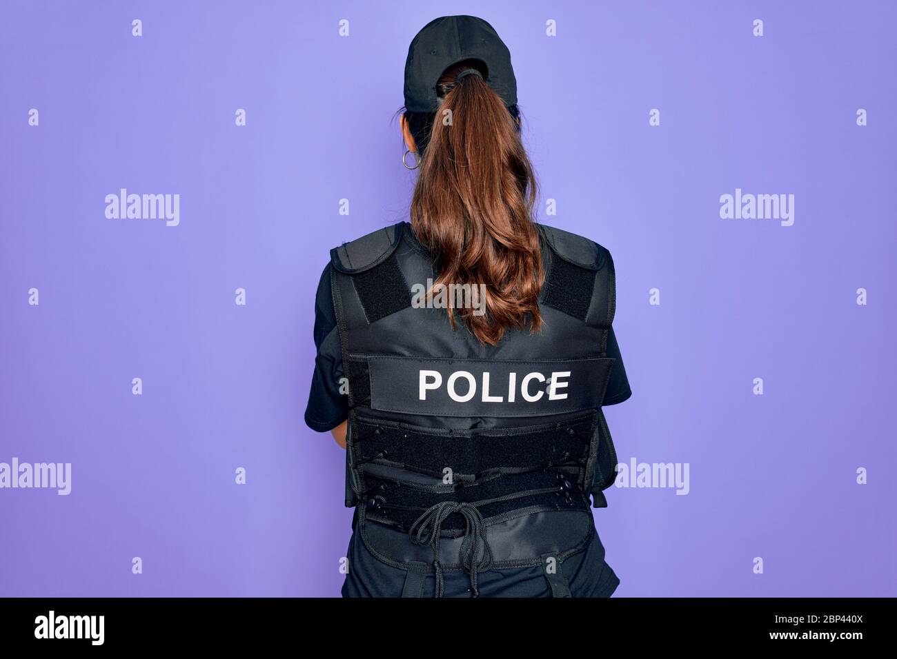 Young police woman wearing security bulletproof vest uniform over ...
