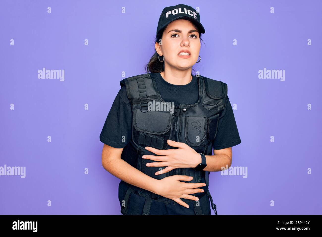 Young police woman wearing security bulletproof vest uniform over ...