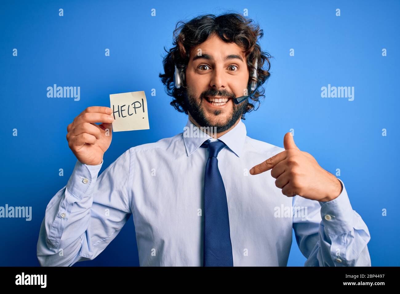 Young handsome call center agent man with beard working using headset ...