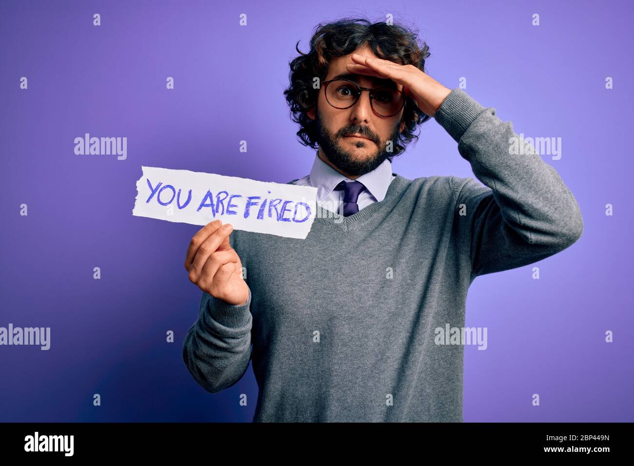 Handsome business man with beard holding you are fired message over ...
