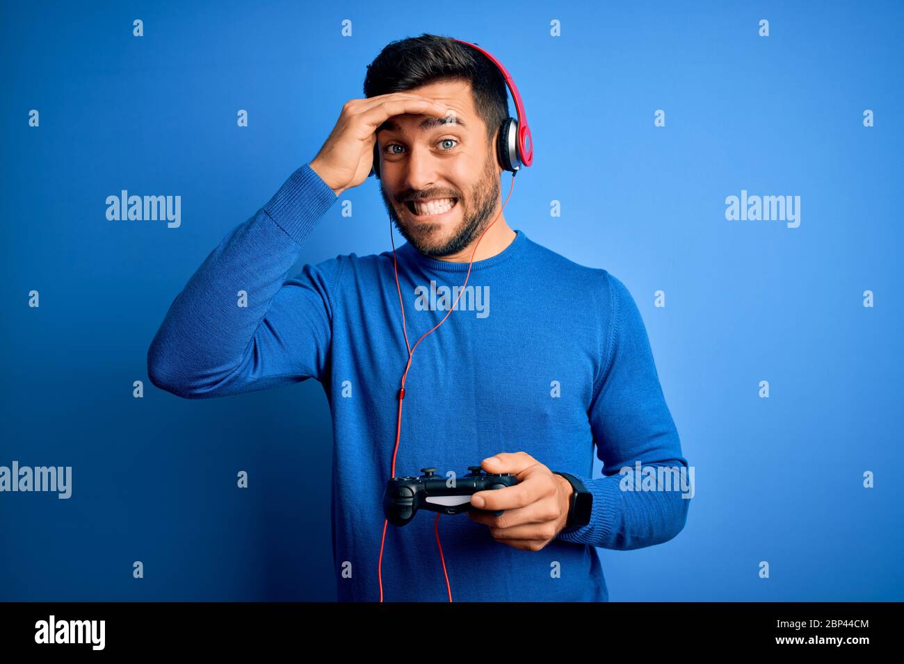 Young handsome gamer man with beard playing video game using joystick ...