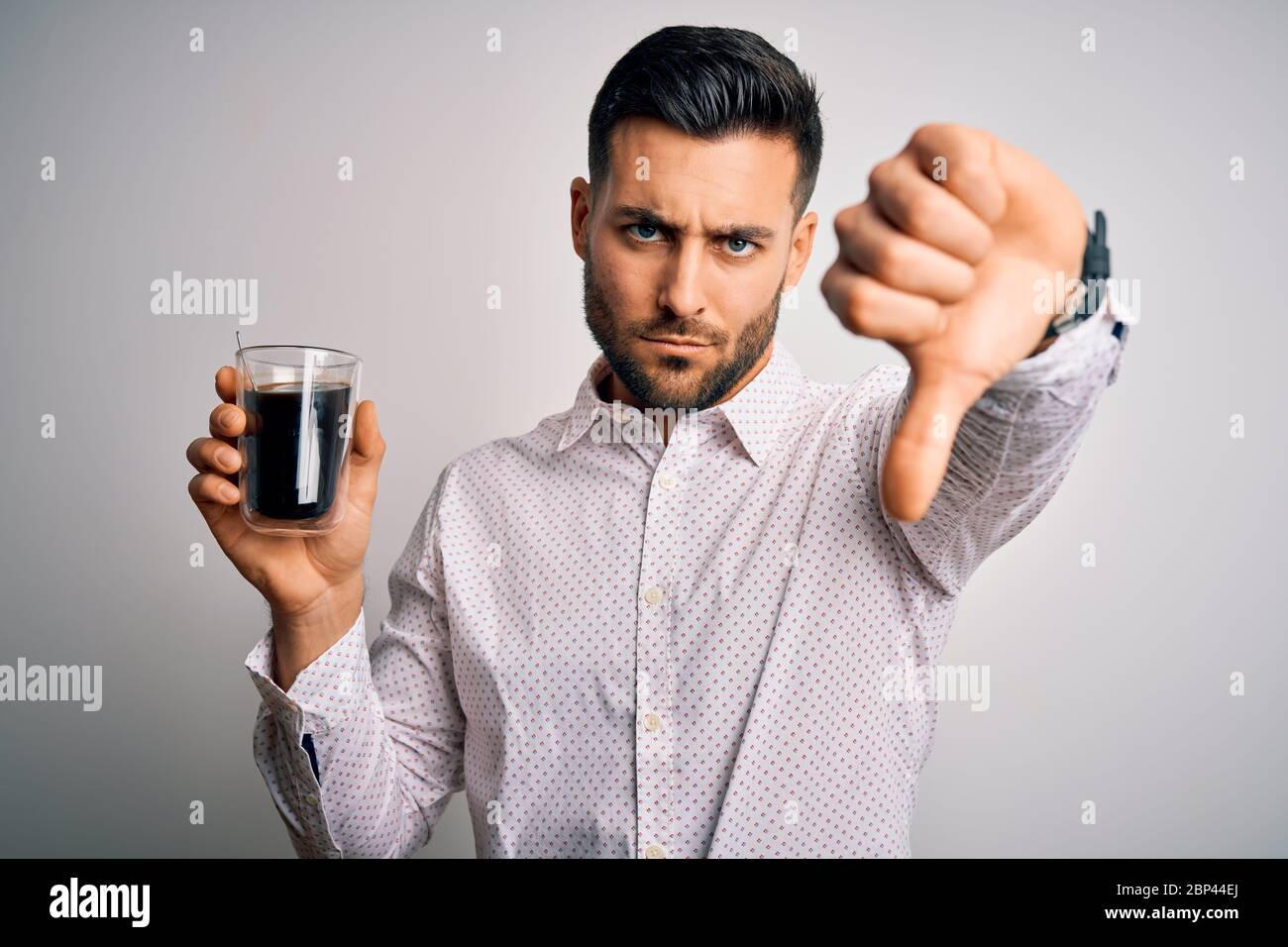 Young handsome man drinking a cup of hot coffee over white isolated ...