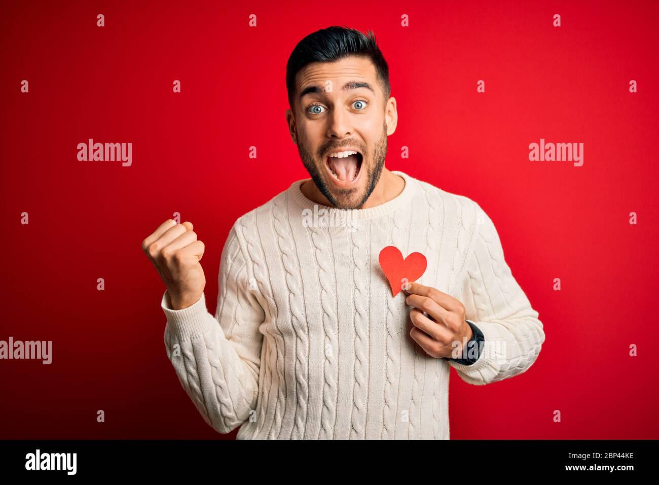 Young handsome man holding red shape heart as romantic and health ...
