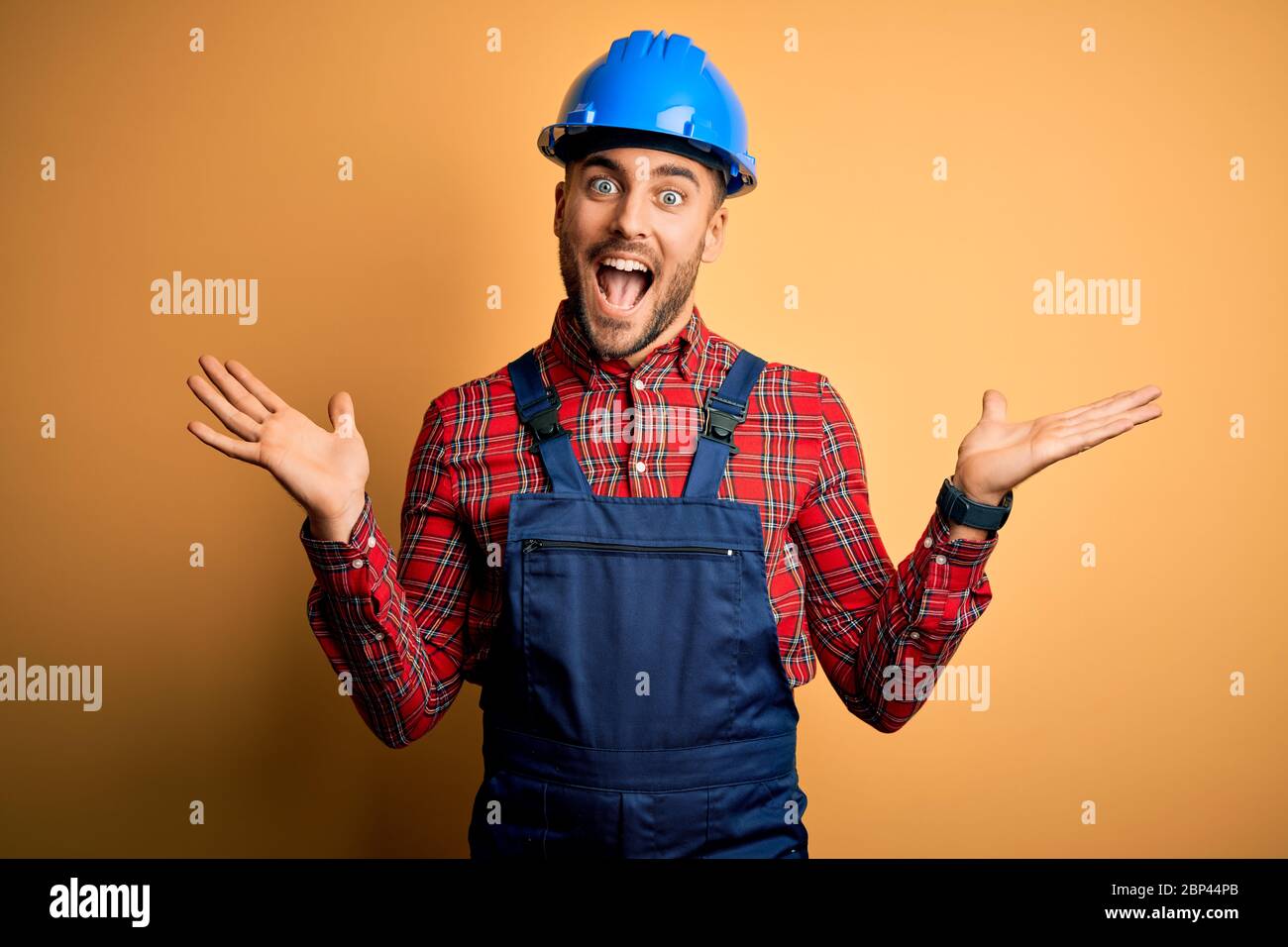 Young builder man wearing construction uniform and safety helmet over ...