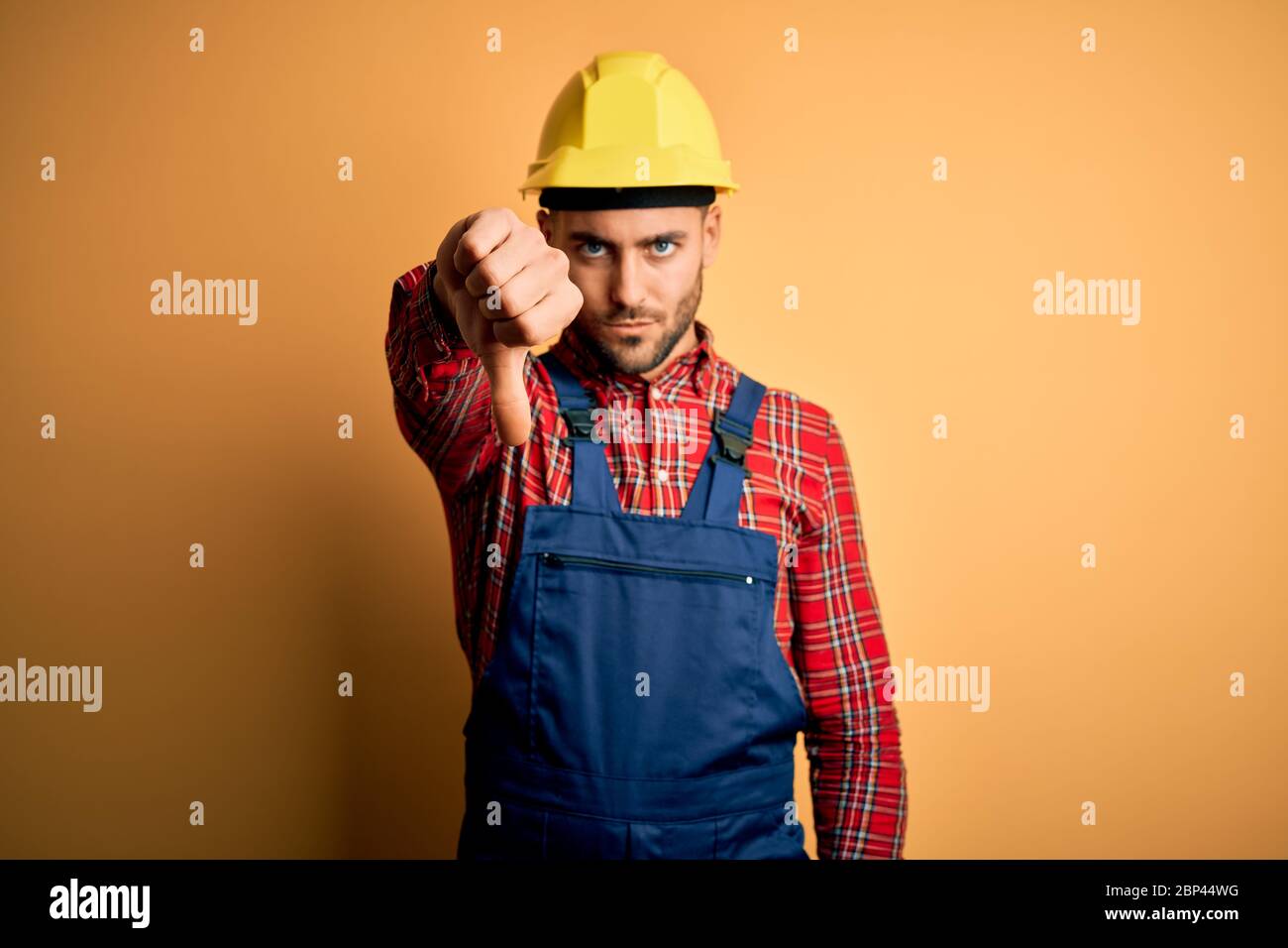 Young builder man wearing construction uniform and safety helmet over ...
