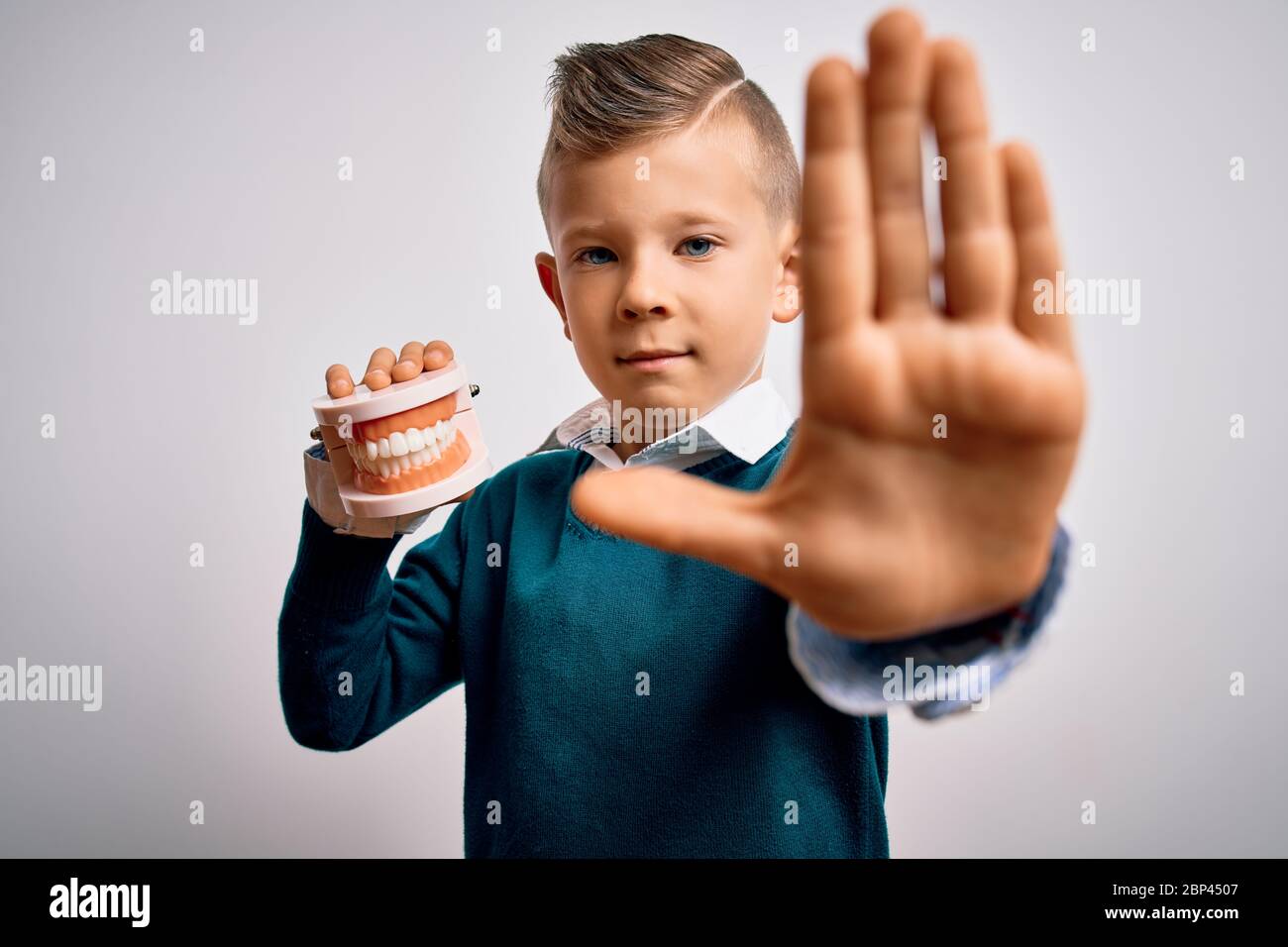 Young little caucasian kid holding dental prosthesis teeth denture over ...
