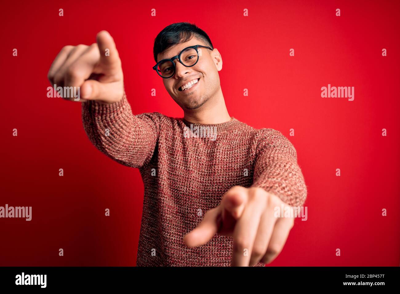 Young handsome hispanic man wearing nerd glasses over red background ...