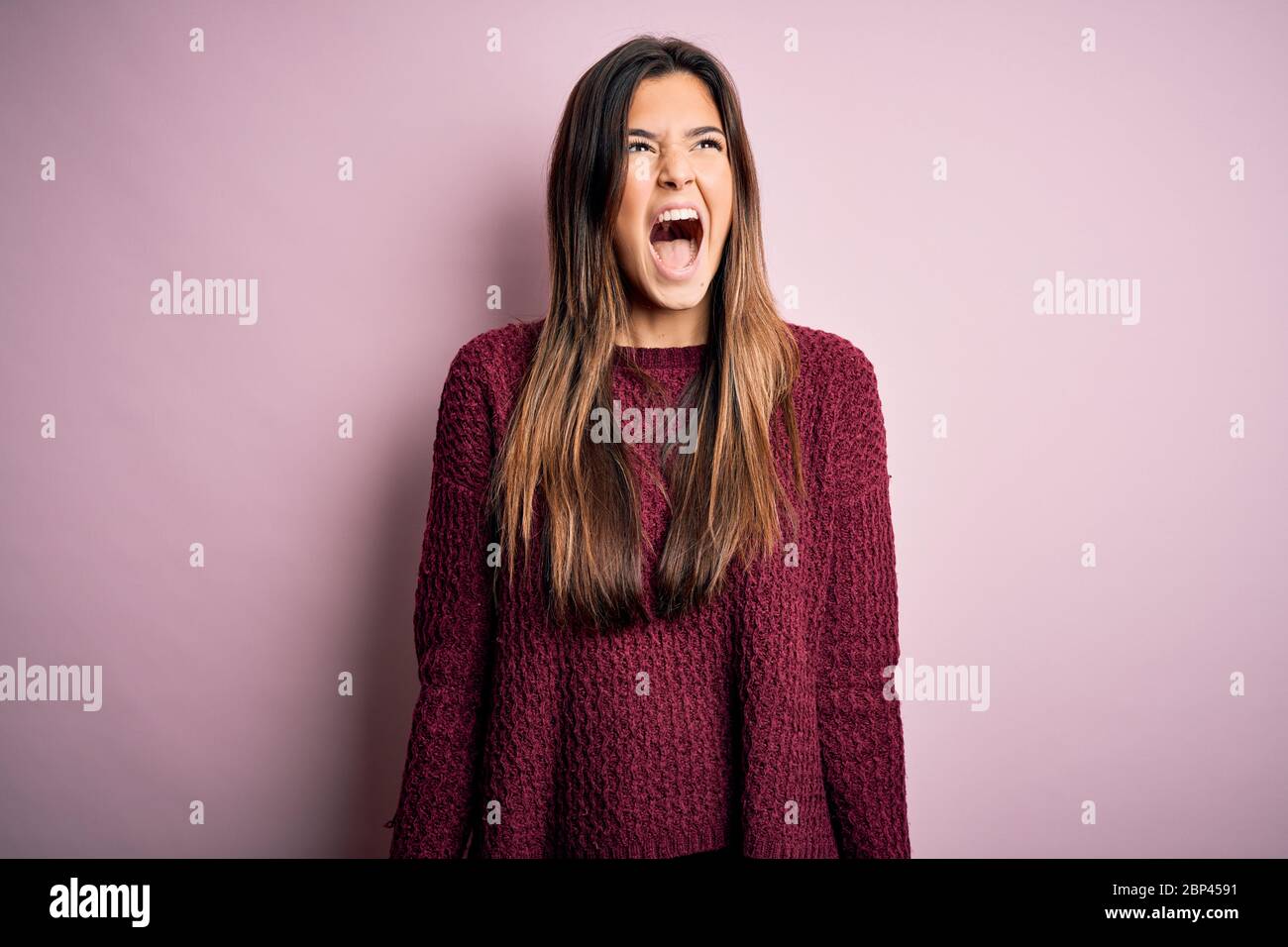 Young beautiful girl wearing casual sweater over isolated pink ...